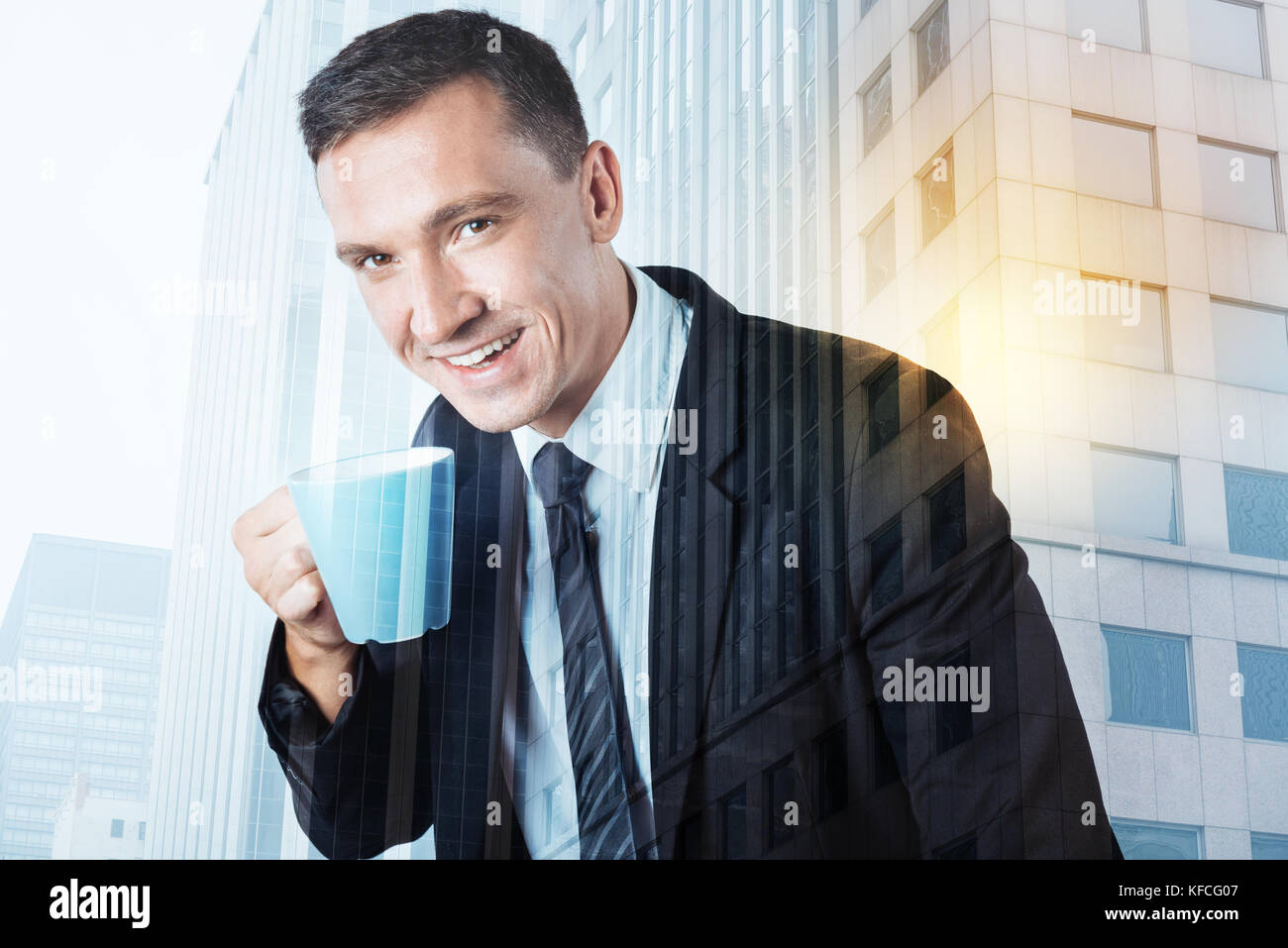 Cheerful delighted man drinking tea Stock Photo - Alamy