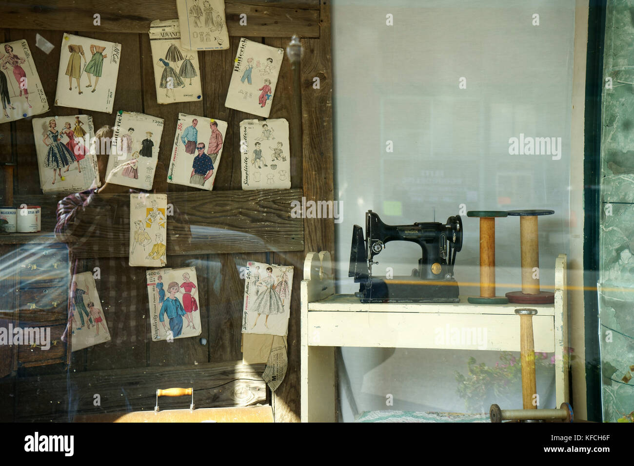 Vintage sewing machine and fashion designs displayed in store window at ...
