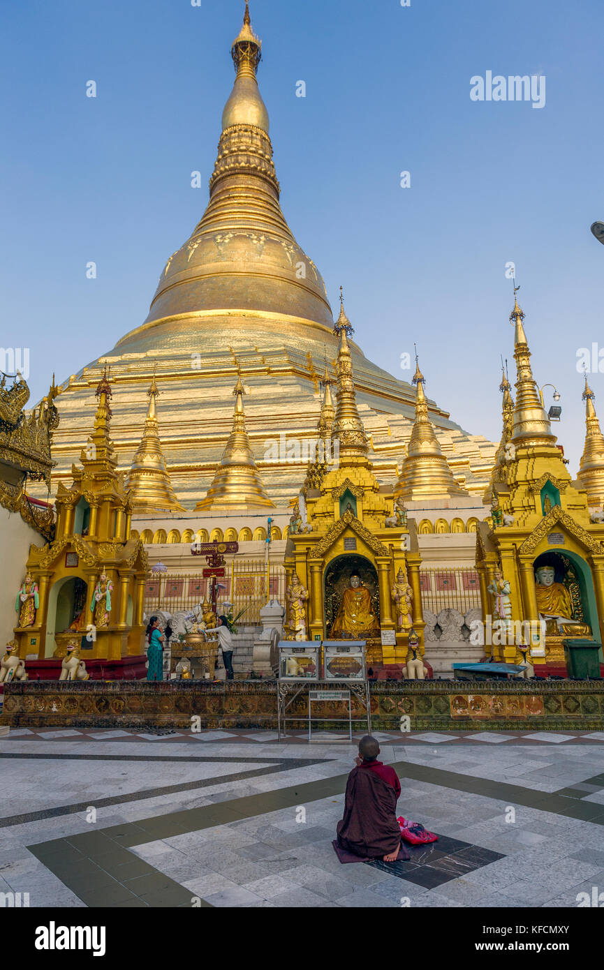 Myanmar (formerly Burma). Yangon. (Rangoon). Monk praying at Shwedagon ...