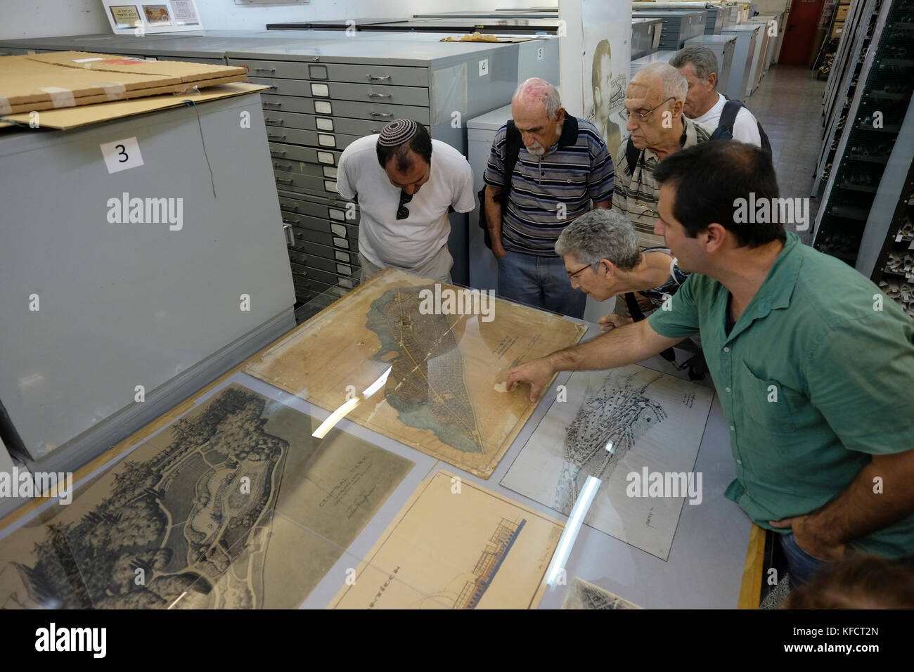 Israeli visitors inspecting original maps and plans of the Jewish state ...