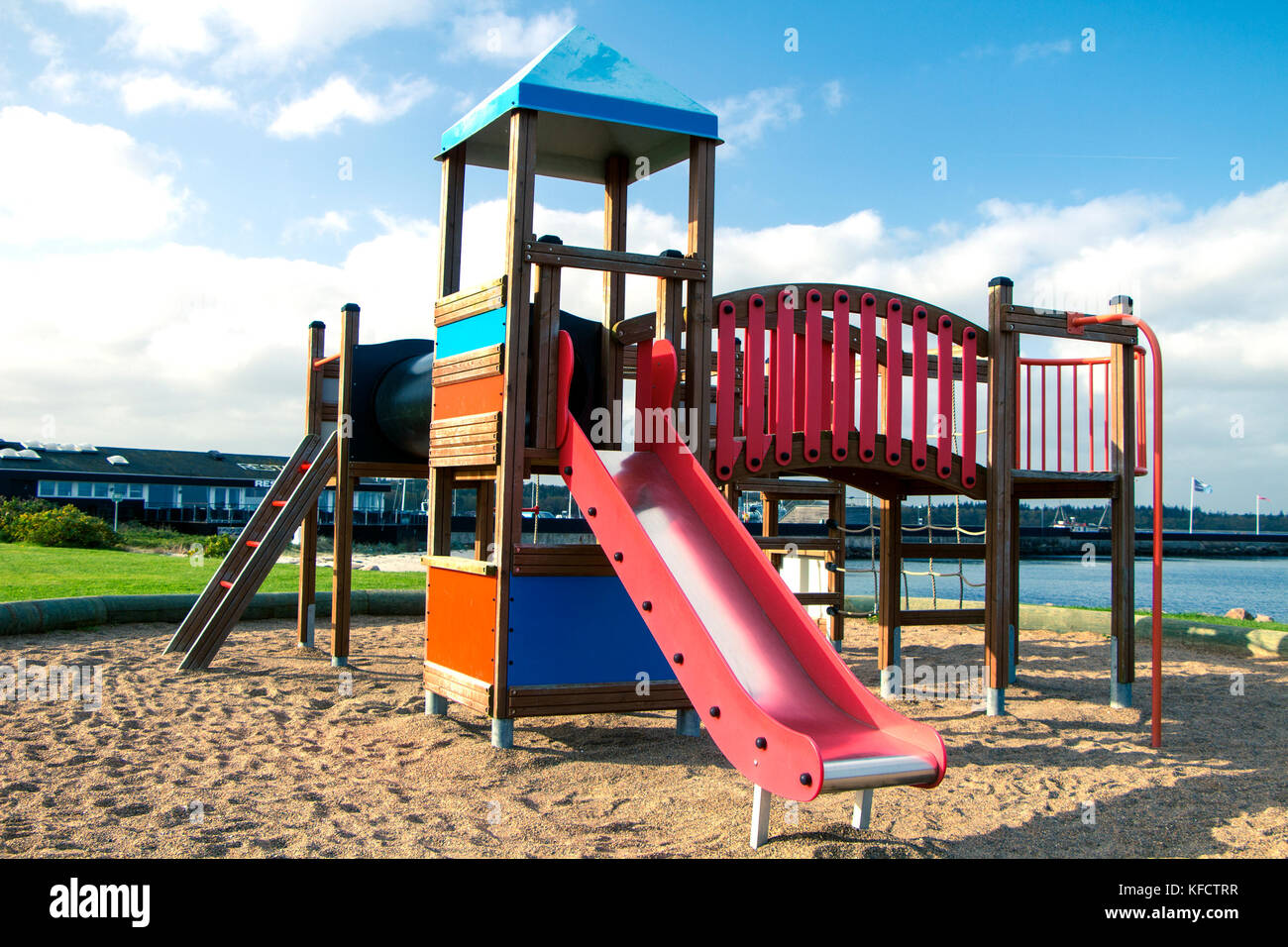 Wooden red and blue playground on sand on a sunny day Stock Photo - Alamy