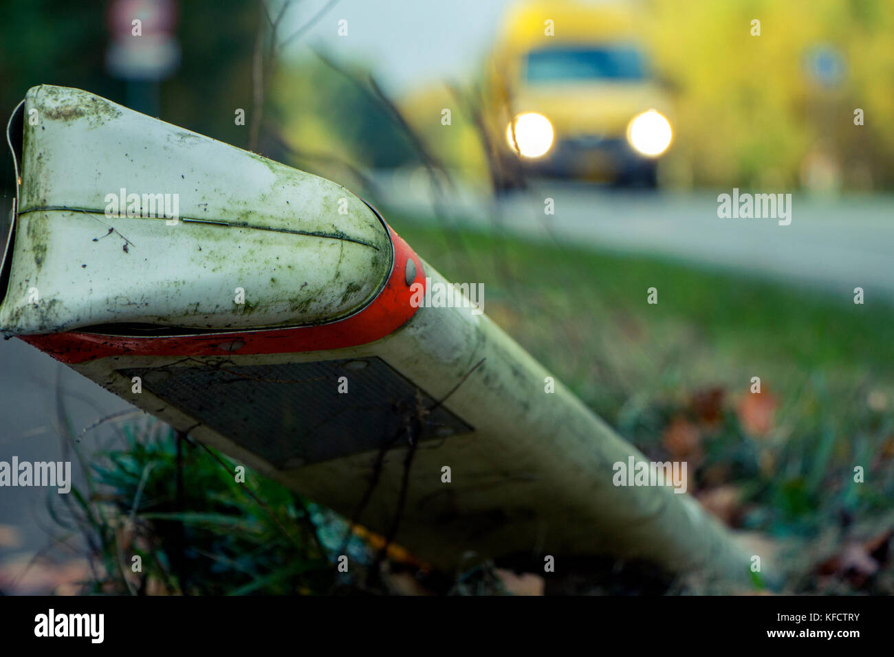 Road sign on grass and yellow car on road Stock Photo - Alamy