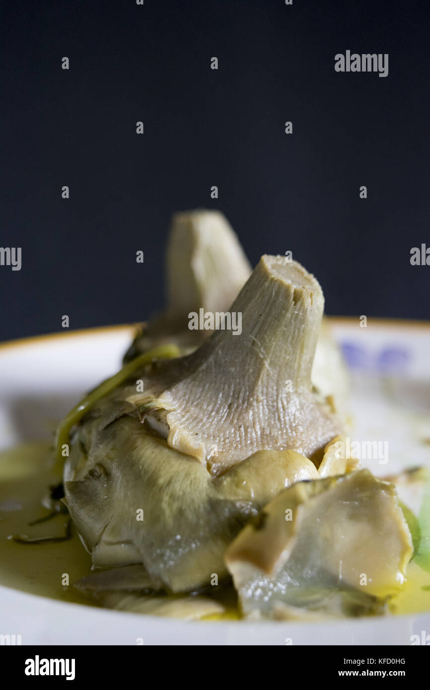 roman style artichokes in a white dish Stock Photo - Alamy