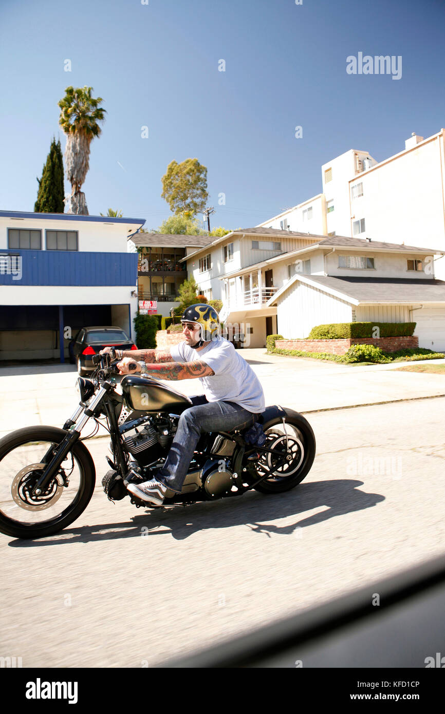 USA, Los Angeles, a motorcyclist riding his motorcycle down the road ...