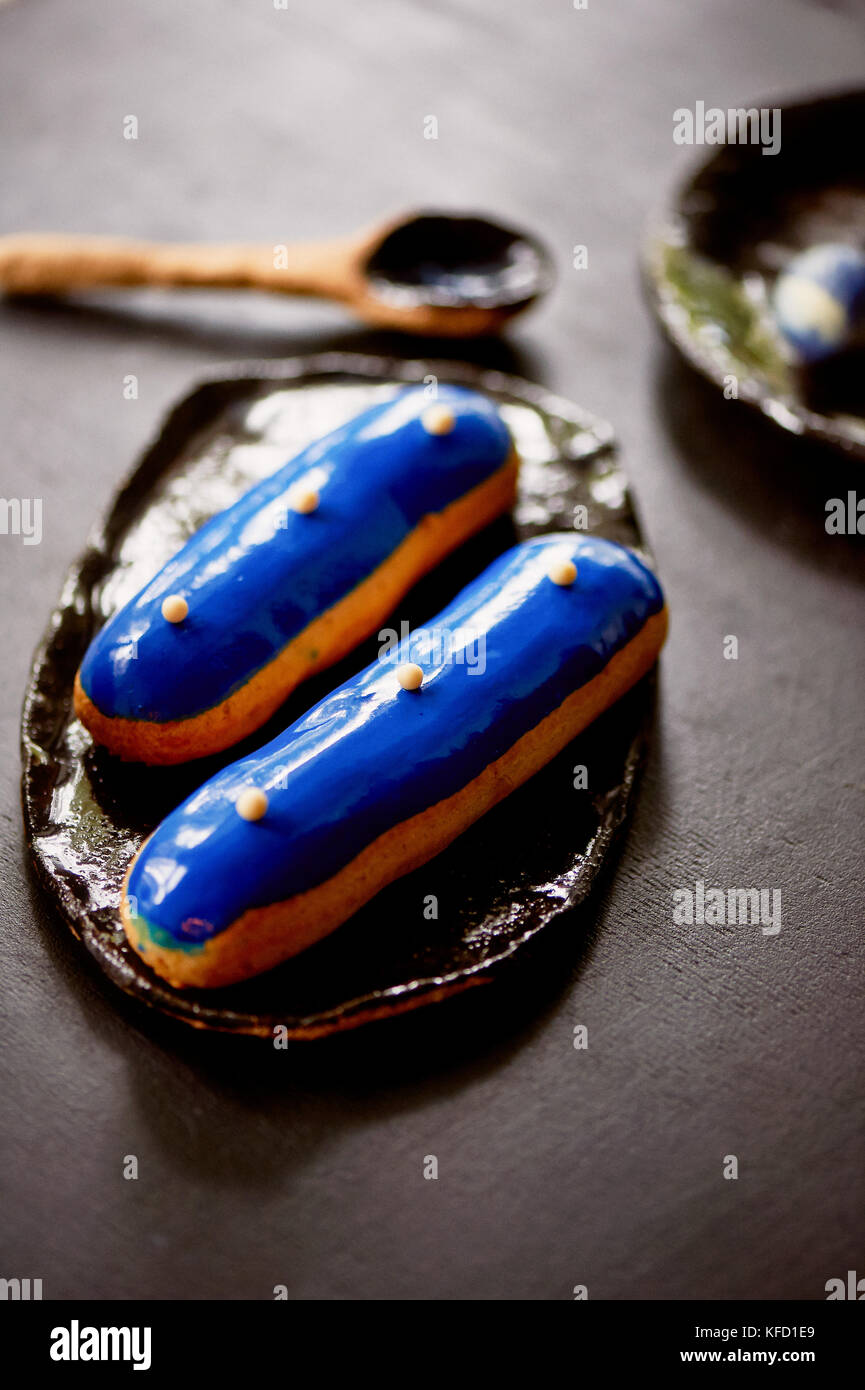 Blue eclairs with a mirrored glaze.A work of culinary art. Cakes Stock ...