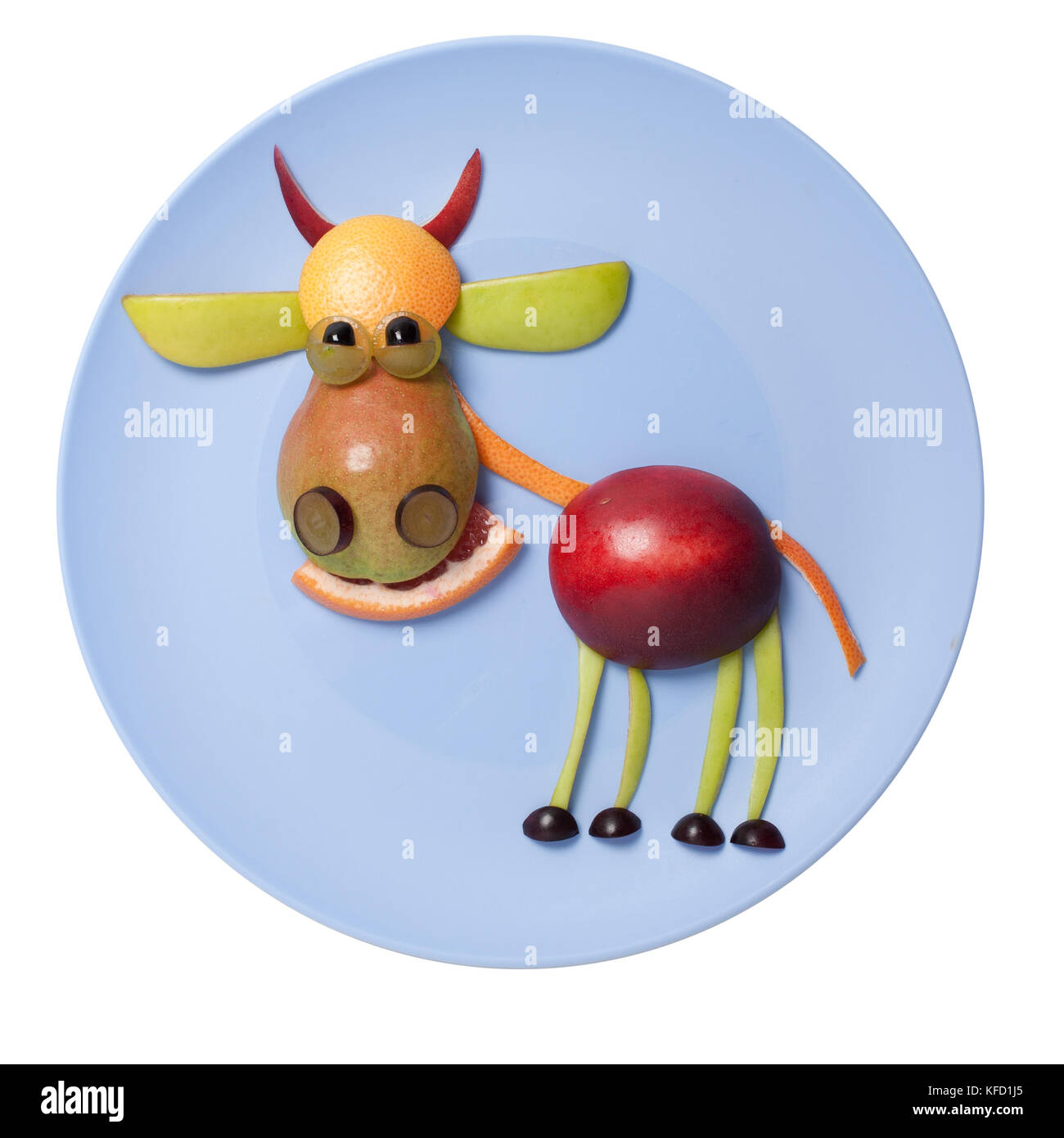 Smiling fruit cow made on blue plate Stock Photo - Alamy