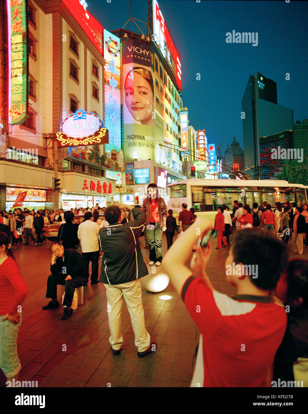 CHINA, Shanghai, people take photos of one another on a busy urban ...