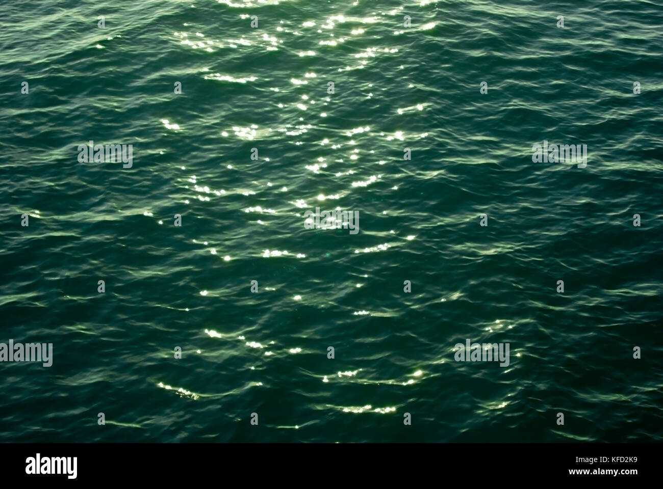 background, texture: sea water surface with sunlight reflections in the ...