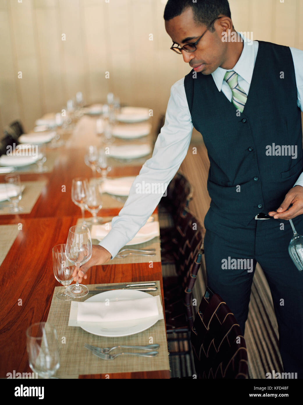 USA, California, Los Angeles, waiter arranging dinner table with wine ...