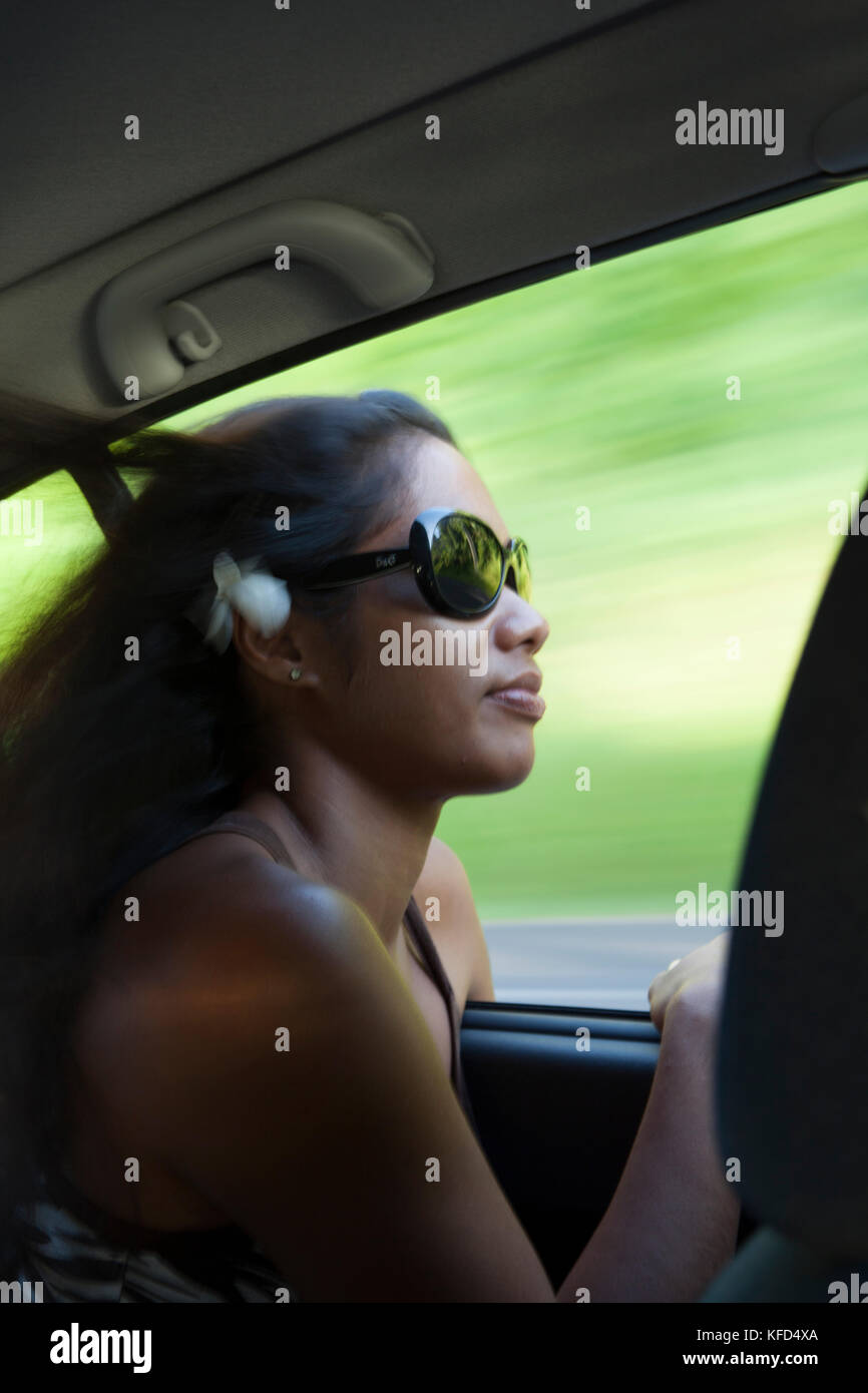 FRENCH POLYNESIA, Tahiti. A portrait of a local girl in a car in ...