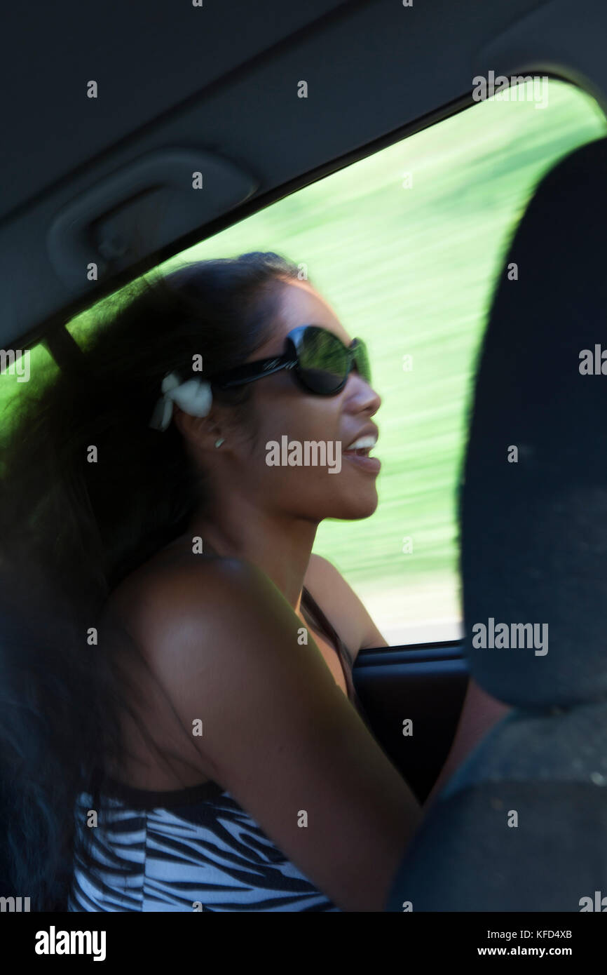 FRENCH POLYNESIA, Tahiti. A portrait of a local girl in a car in ...