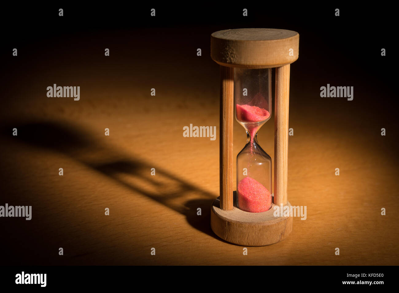 Closeup of a small running hourglass low key Stock Photo - Alamy
