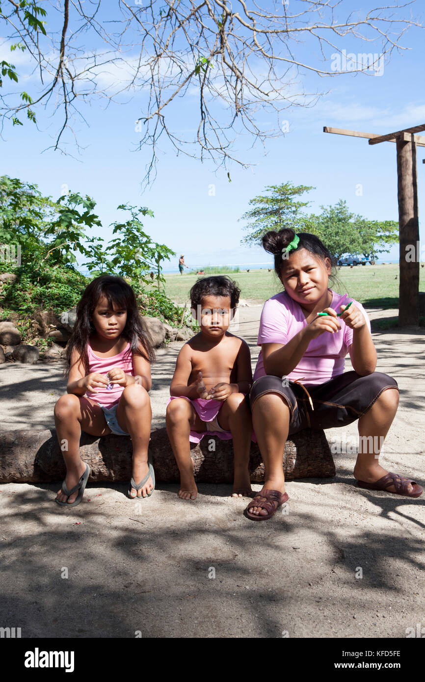 FRENCH POLYNESIA, Moorea. Portrait of local kids sitting on the side of ...