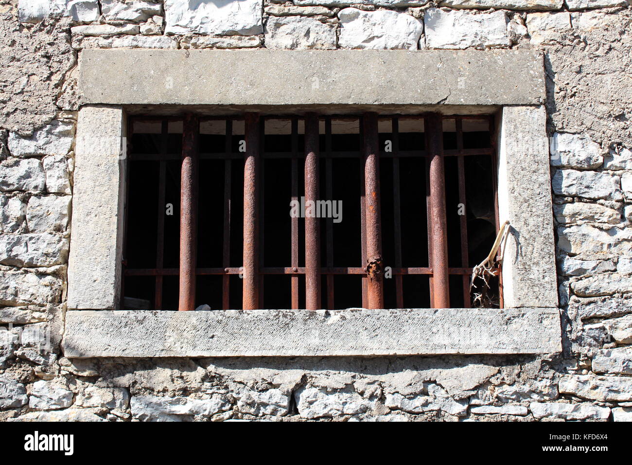 Stone window with massive frame and hard rusted metal bars in ...