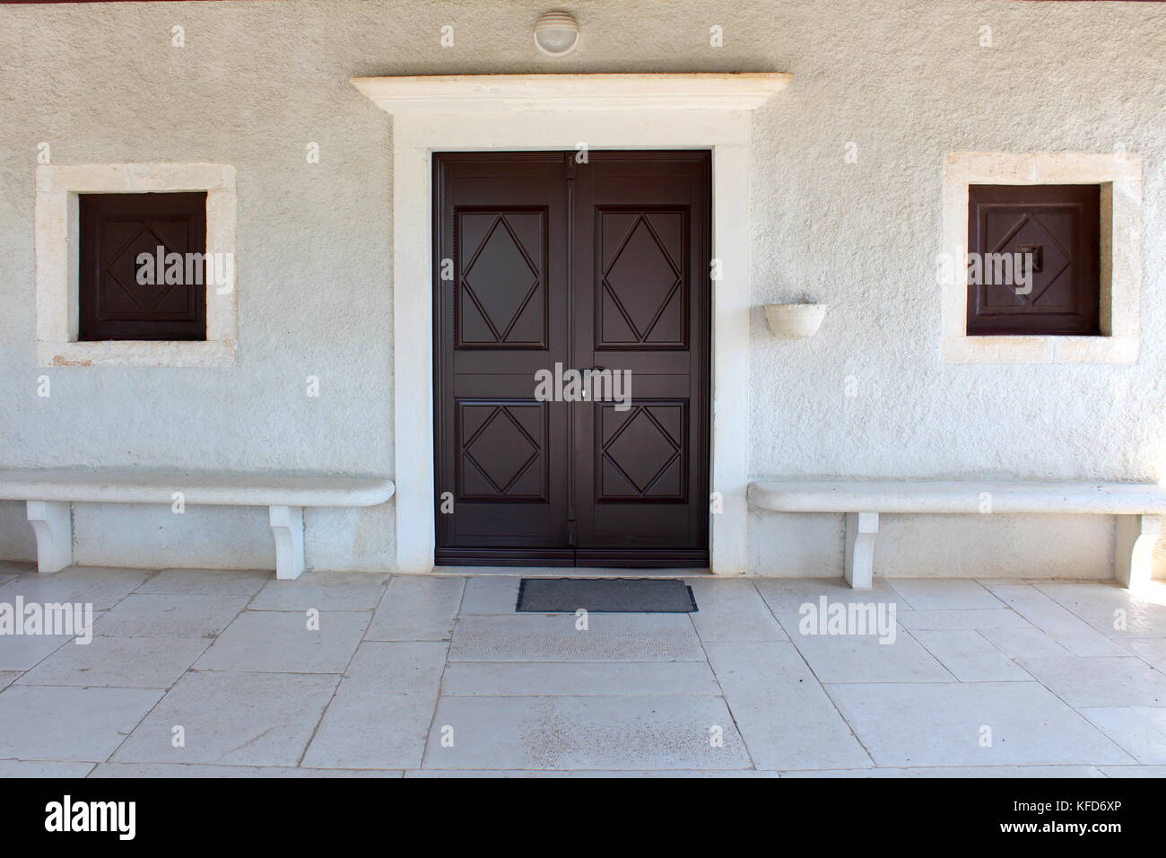 Massive new wooden chapel doors and windows on stone wall with stone ...