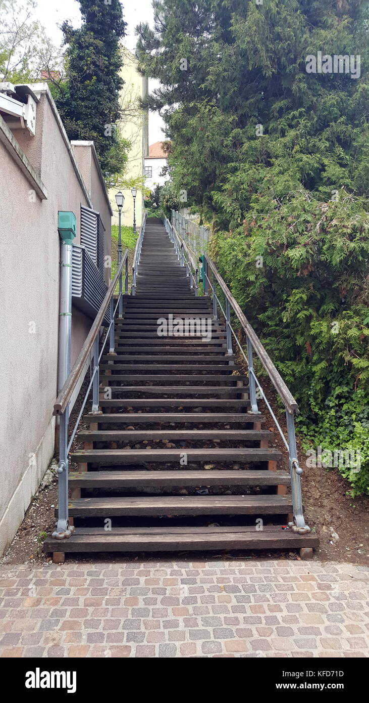 Wooden city steps with metal hand bars and antique baroque light ...