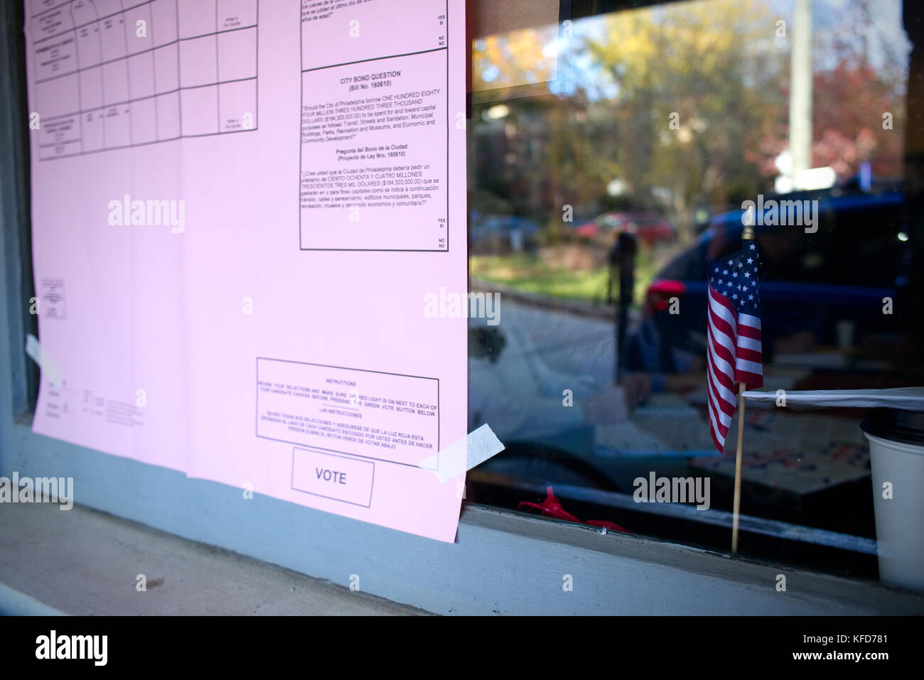 Small American flag sits behind a window of a polling station and an ...