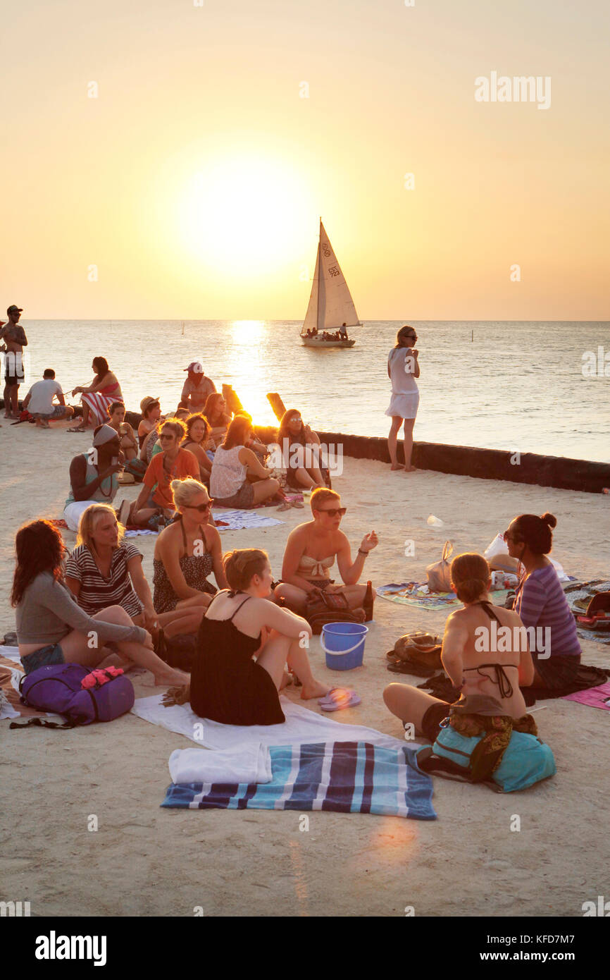 BELIZE, Caye Caulker, tourists enjoy the beach and sunset at the Lazy ...