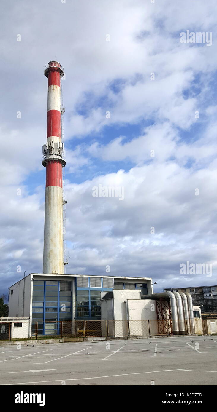 Old small power plant building with high industrial chimney and steel ...