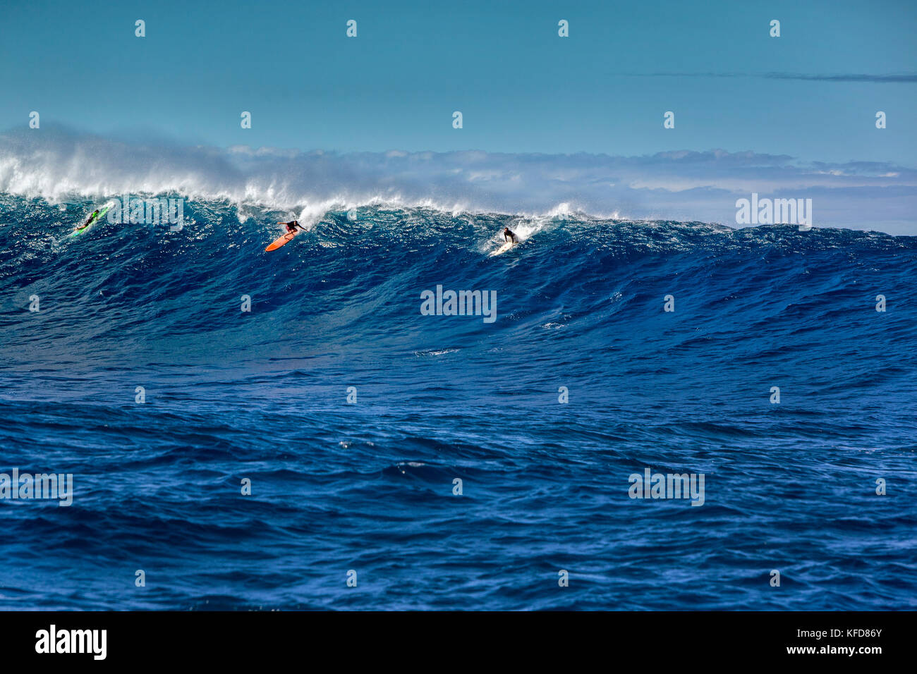 USA, HAWAII, Maui, Jaws, big wave surfers taking off on a wave at Peahi ...