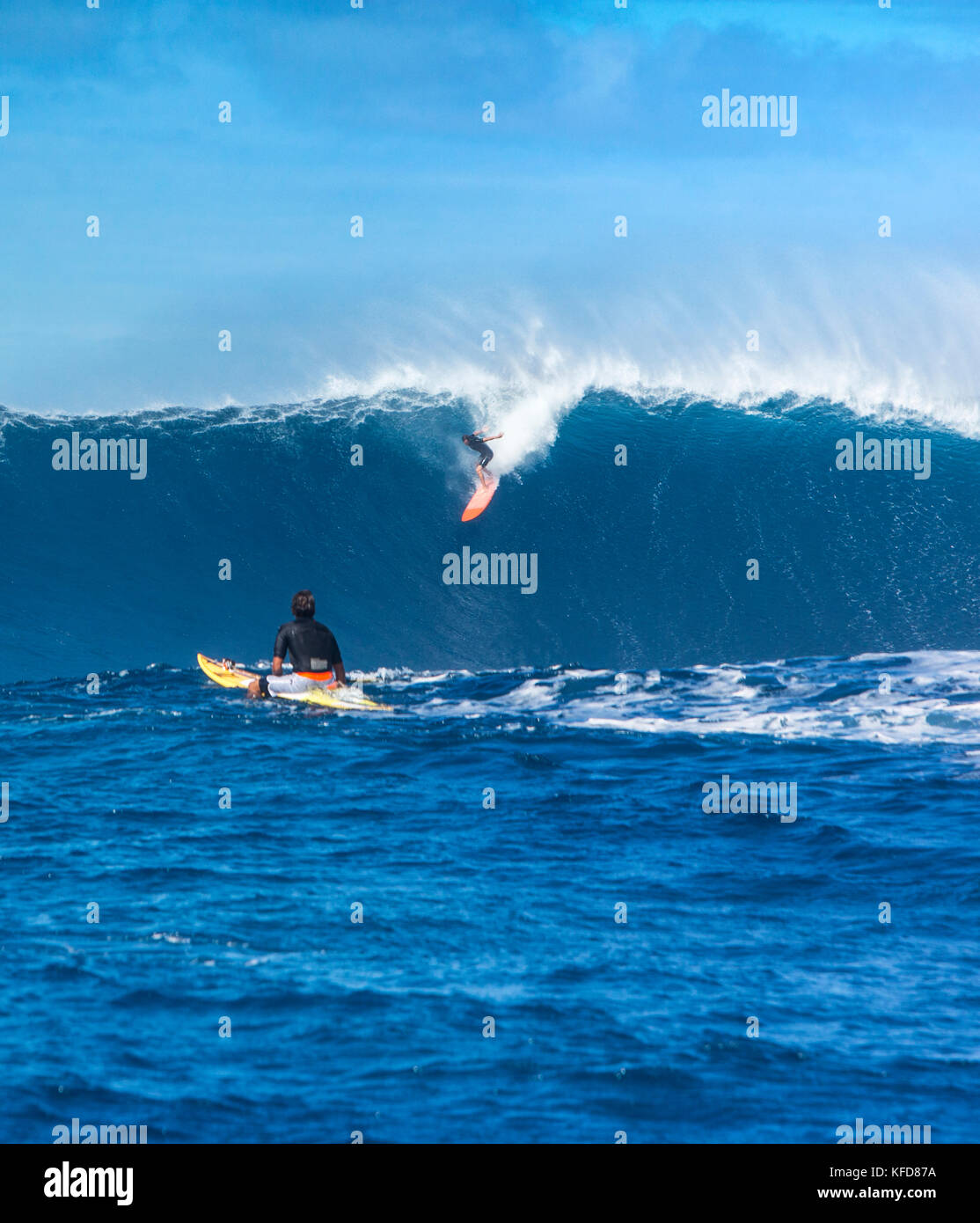 USA, HAWAII, Maui, Jaws, big wave surfers taking off on a wave at Peahi ...