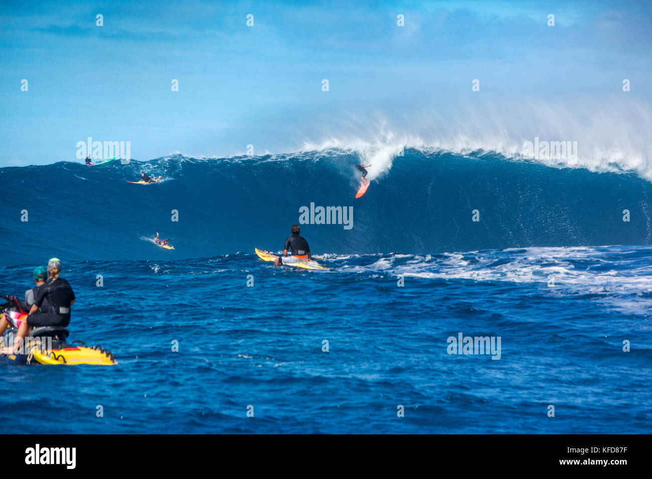 USA, HAWAII, Maui, Jaws, big wave surfers taking off on a wave at Peahi ...