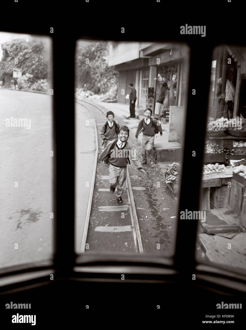 INDIA, West Bengal, school students chasing train on tracks, Darjeeling ...