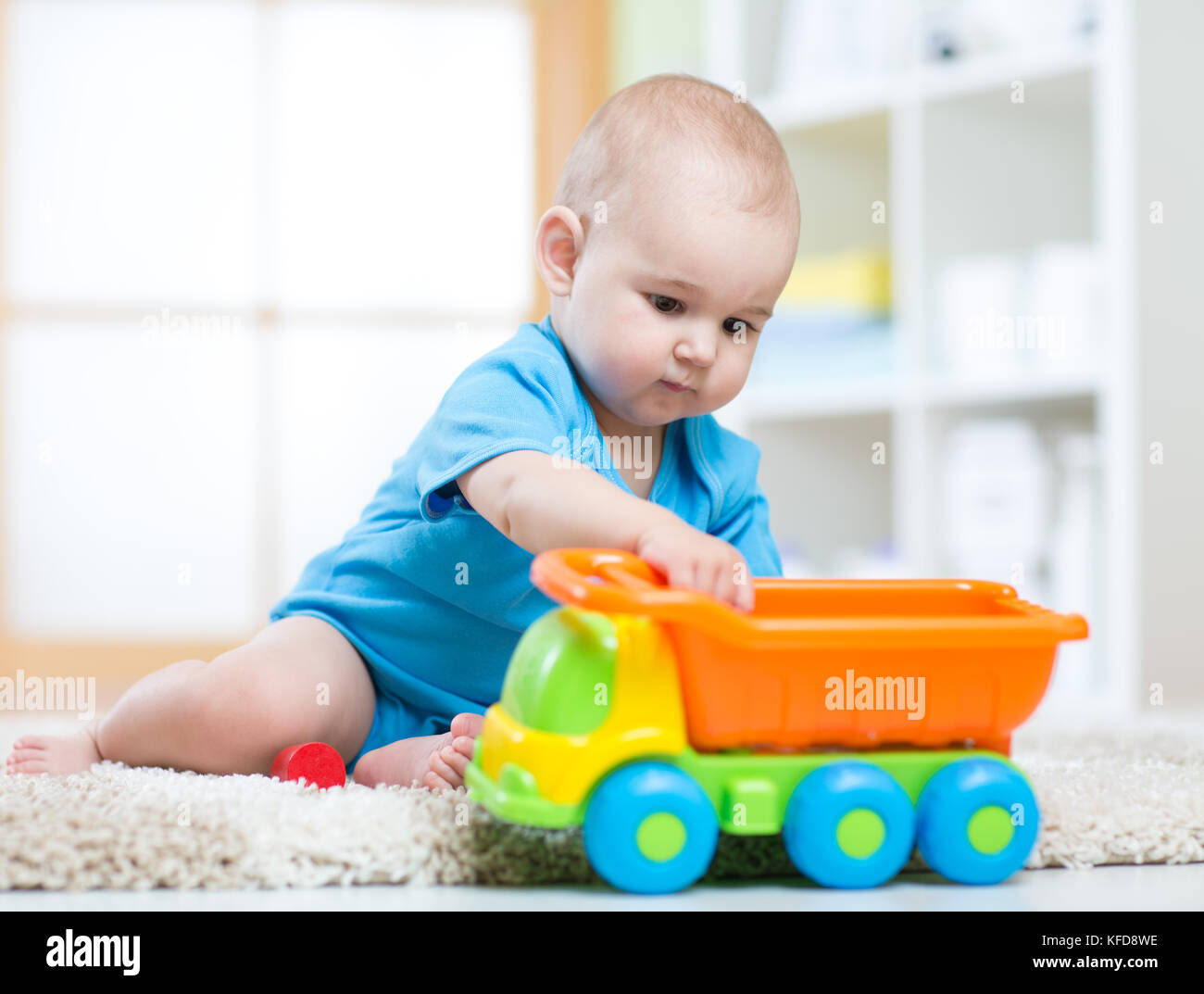child boy toddler playing with toy car in nursery Stock Photo - Alamy