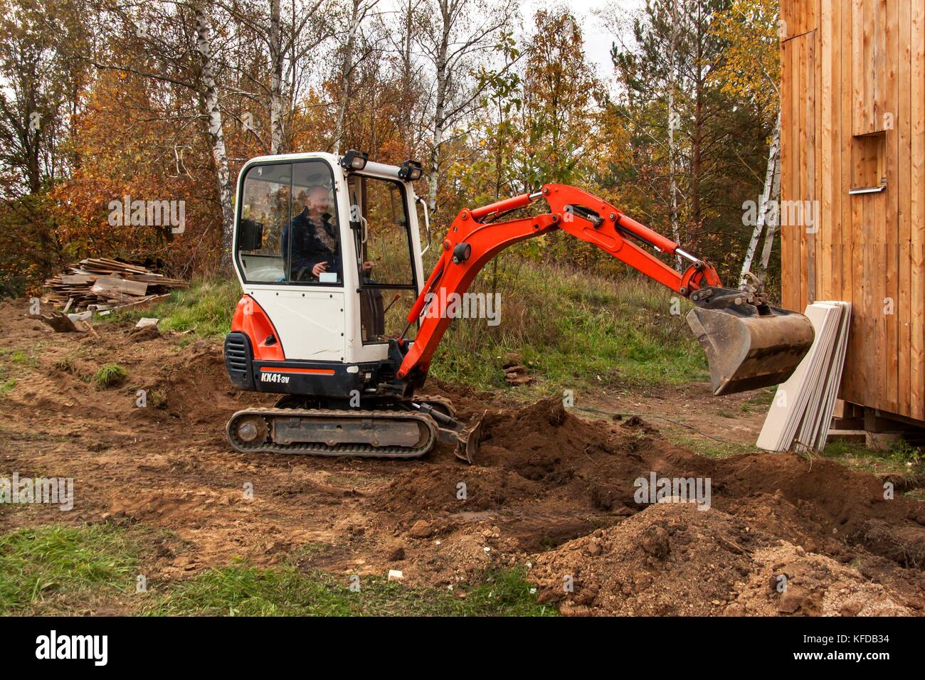 Mini excavator on construction site. Excavator regulates the terrain ...