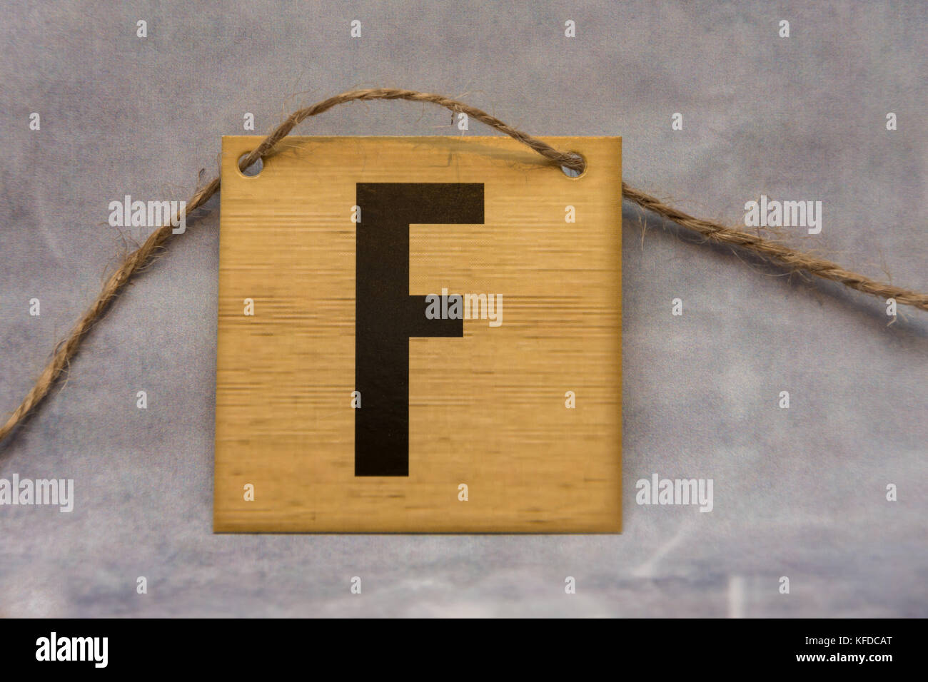 isolated tile letter of the alphabet on a patterned grey background ...