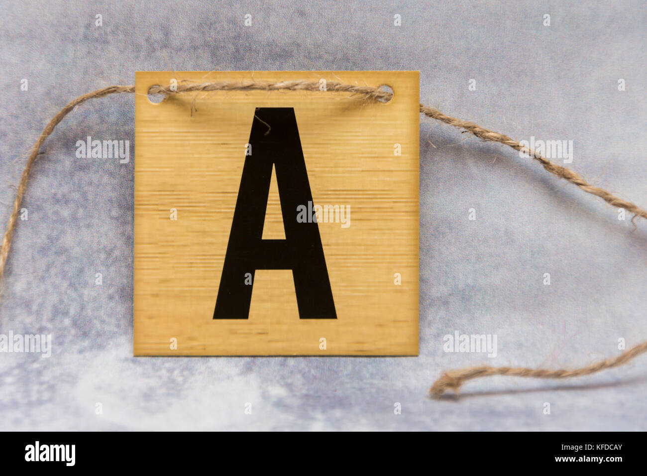 isolated tile letter of the alphabet on a patterned grey background ...