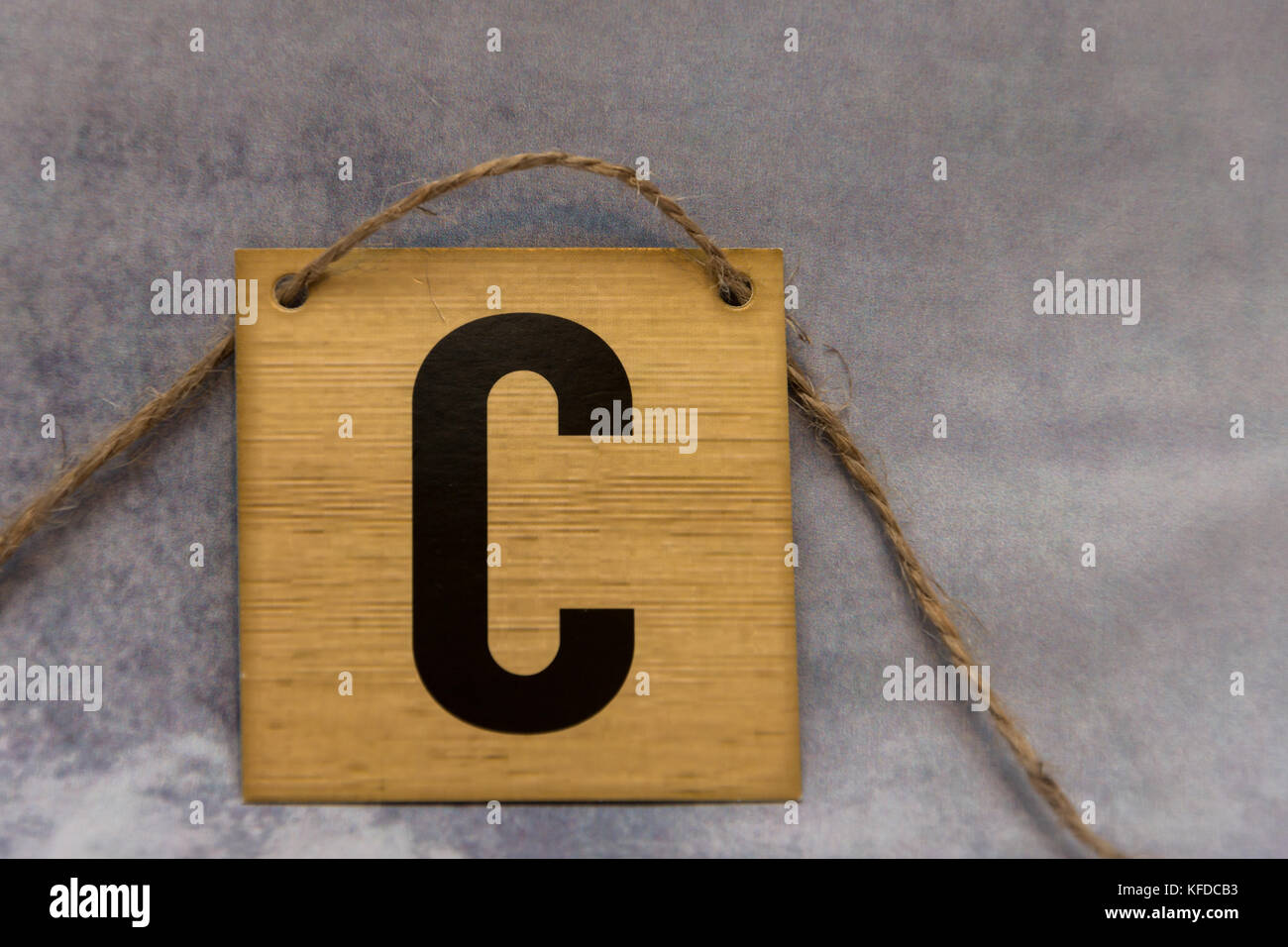 isolated tile letter of the alphabet on a patterned grey background ...
