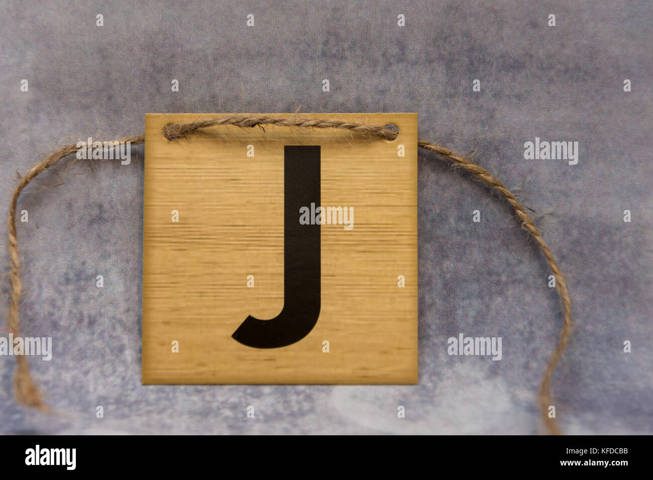 isolated tile letter of the alphabet on a patterned grey background ...