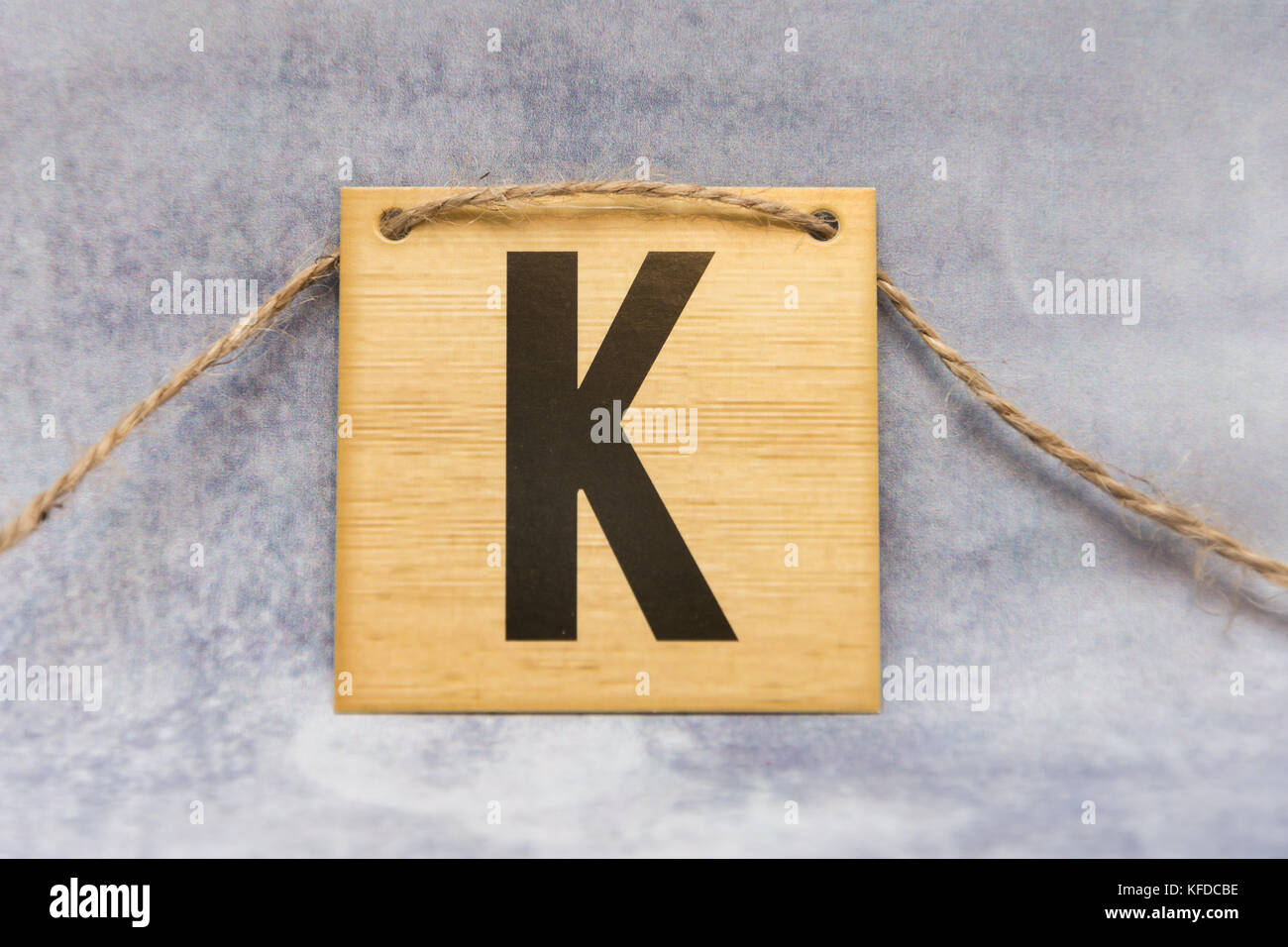 isolated tile letter of the alphabet on a patterned grey background ...