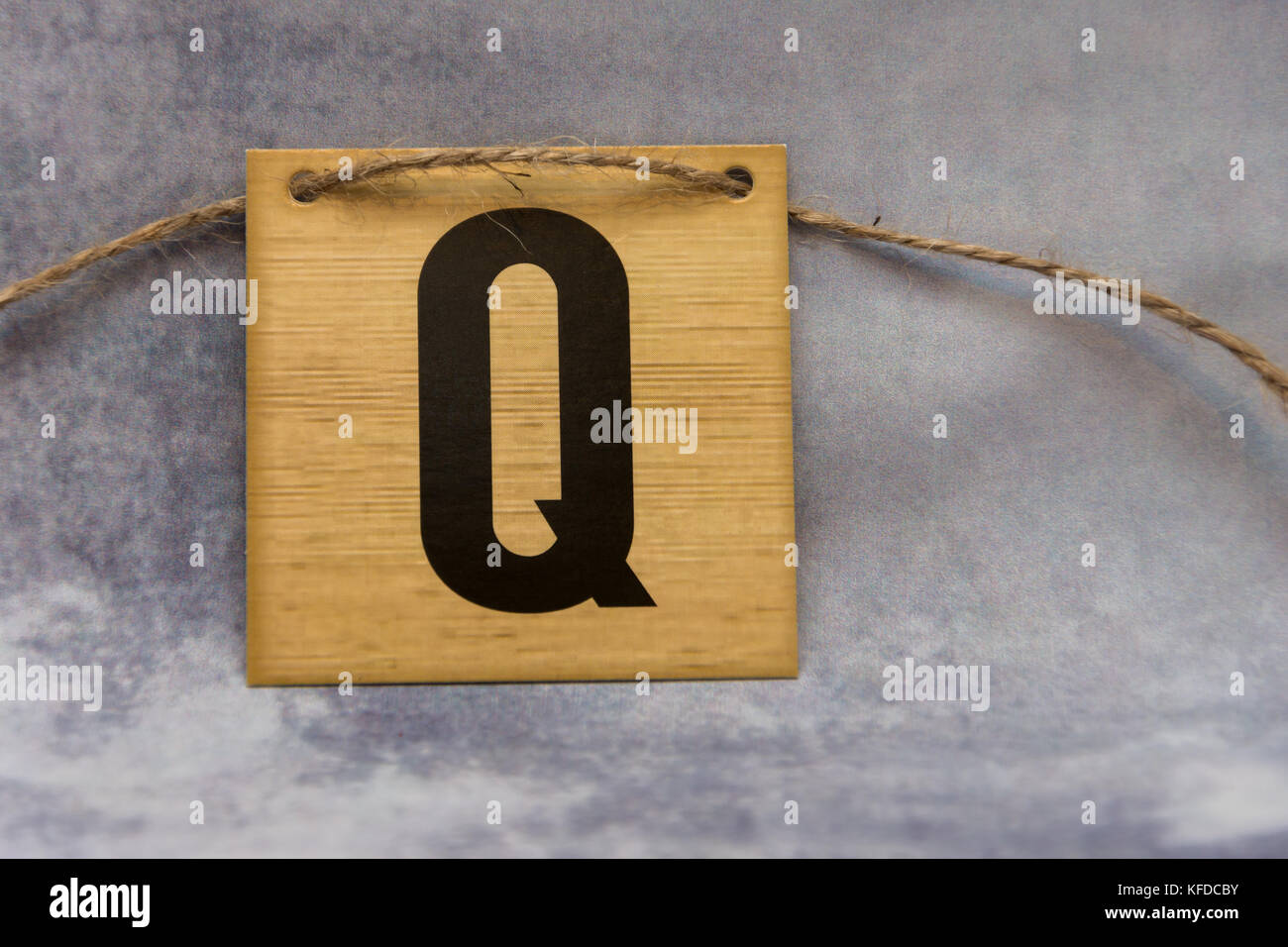 isolated tile letter of the alphabet on a patterned grey background ...