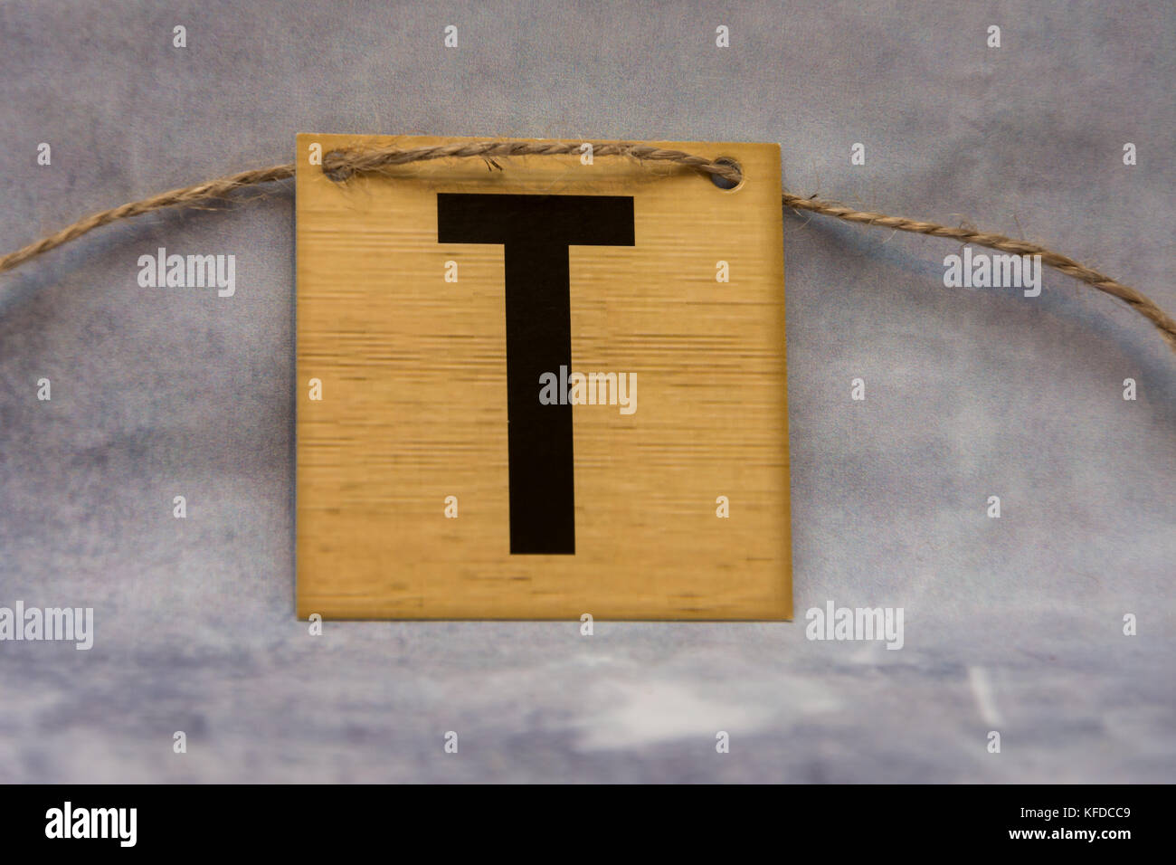 isolated tile letter of the alphabet on a patterned grey background ...