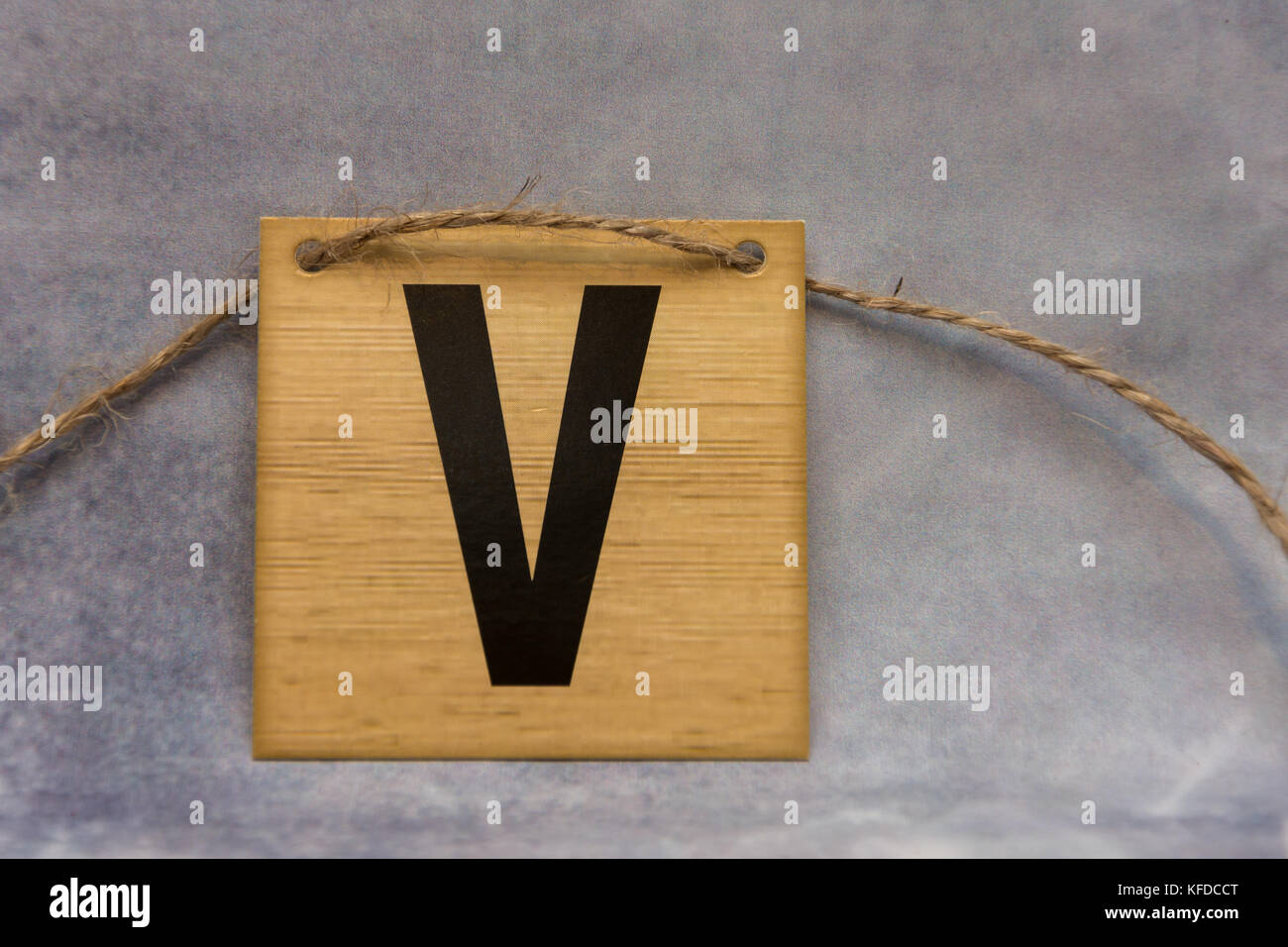 isolated tile letter of the alphabet on a patterned grey background ...