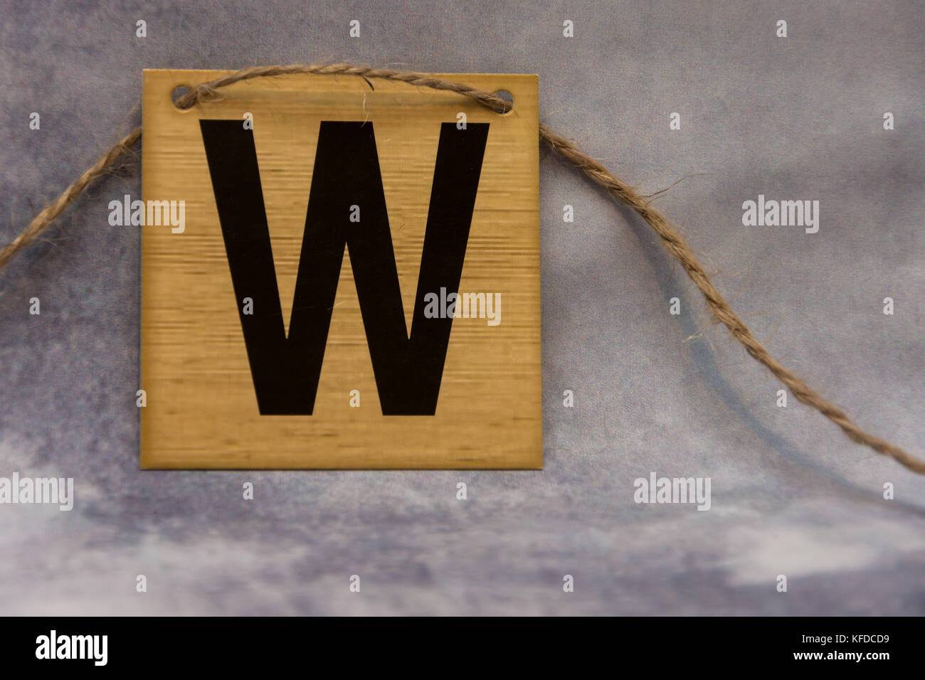 isolated tile letter of the alphabet on a patterned grey background ...