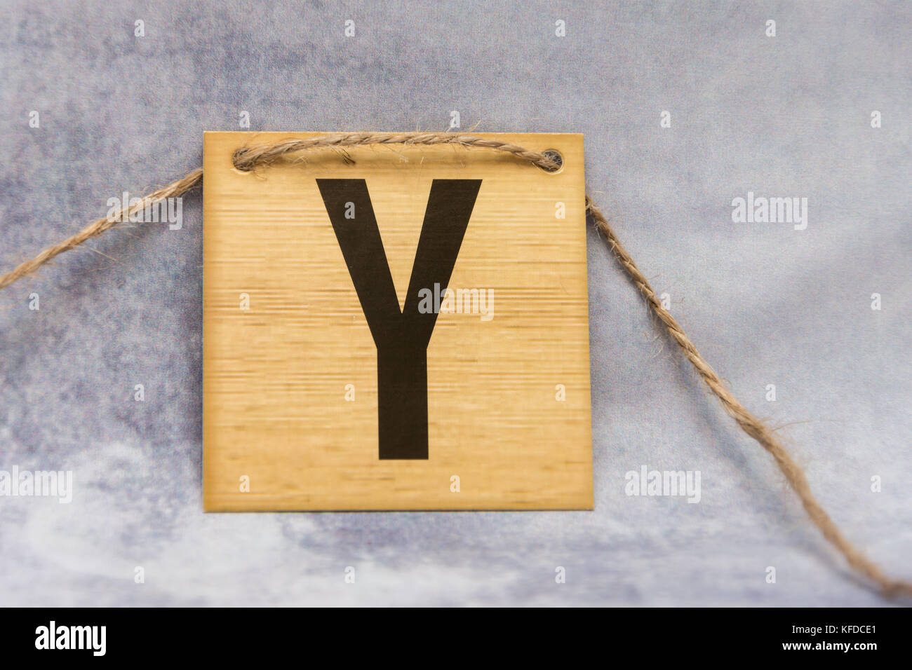 isolated tile letter of the alphabet on a patterned grey background ...