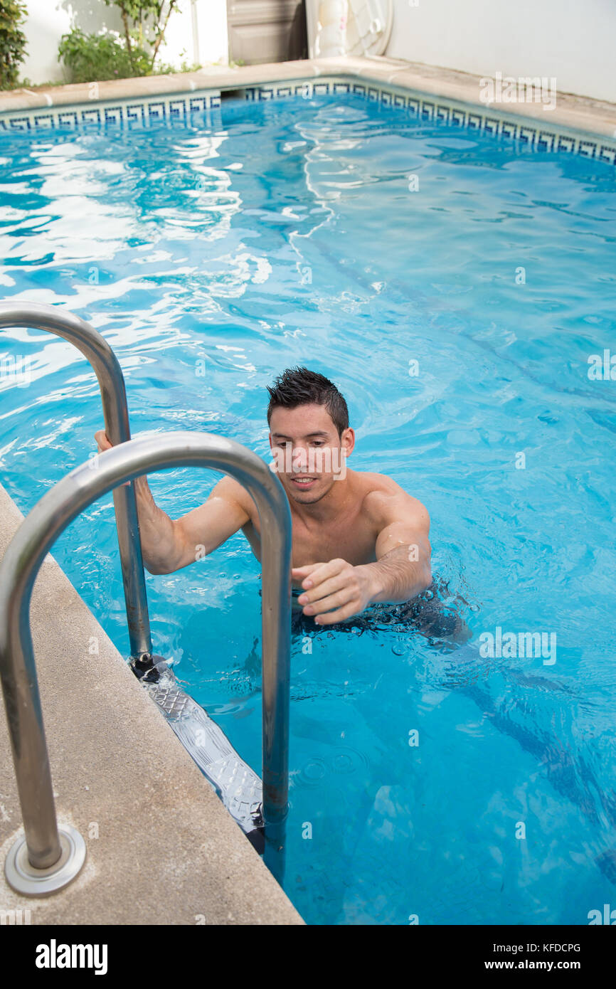 Young strong man climbing the stairs of the pool to get out Stock Photo ...