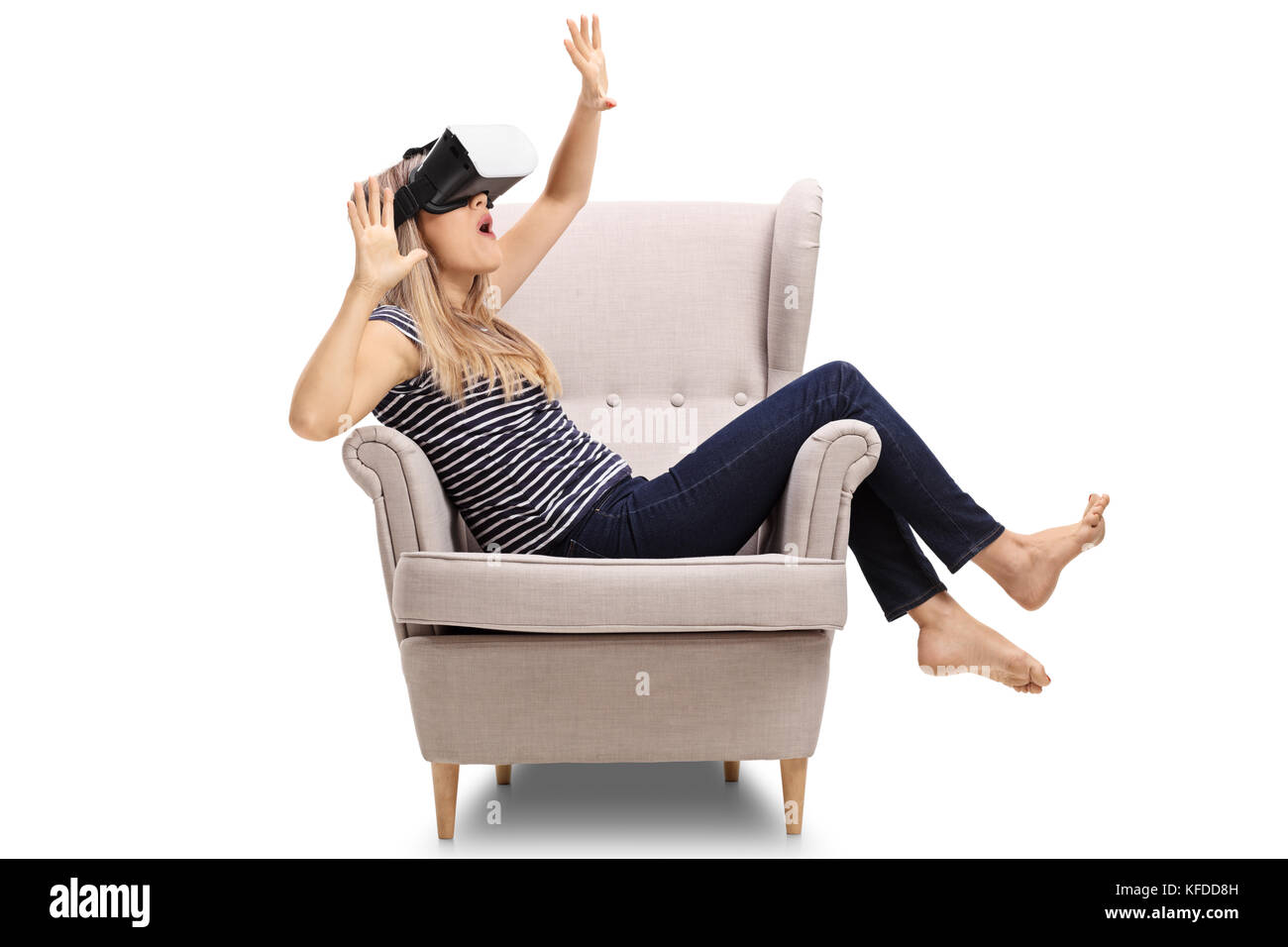 Young woman seated in an armchair experiencing virtual reality through ...