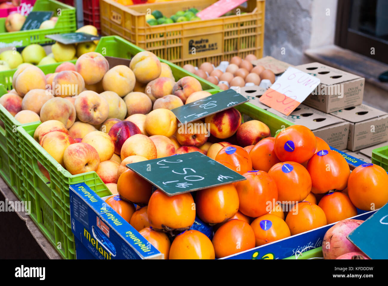 Peaches and persimmon fruits for sale at Sineu market, Mallorca, Spain ...