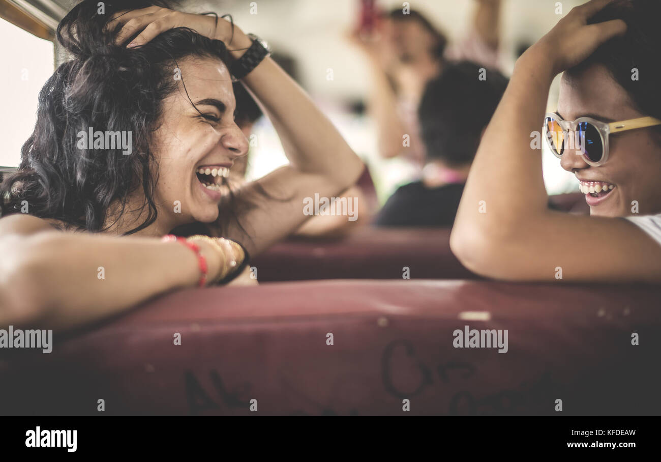 Two young women, friends laughing together on a school bus Stock Photo ...