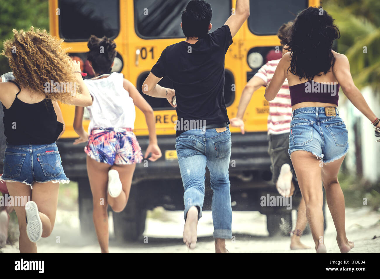 A group of young people chasing a moving school bus Stock Photo - Alamy