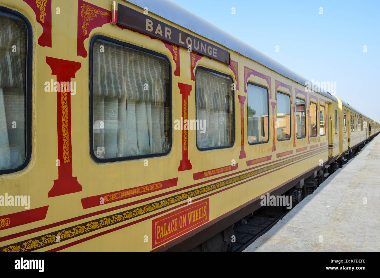 Train carriages in red and yellow livery colours, at a station in ...