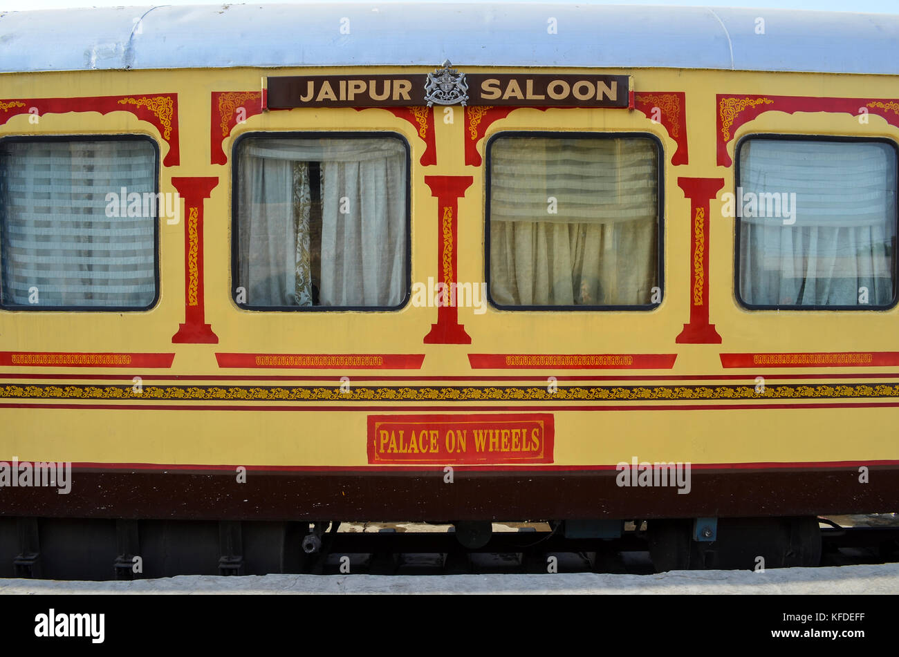 Train carriages in red and yellow livery colours, at a station in ...