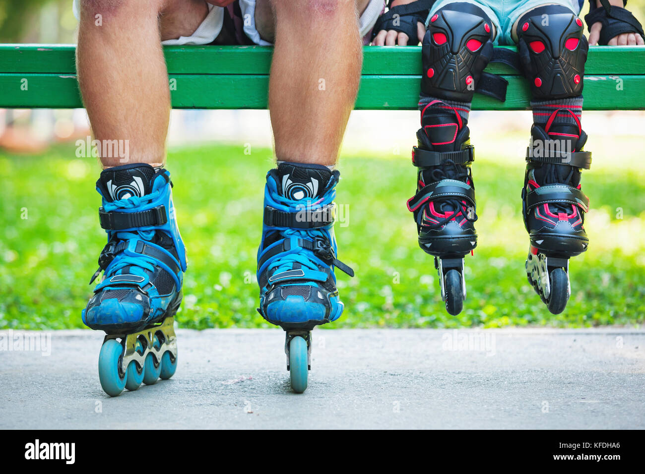 Close up photo of legs in inline skates sitting on bench. Learning ...