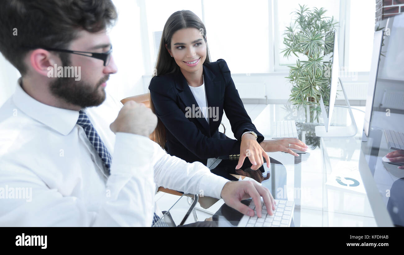 closeup of a businessman and his female assistant sitting at a Desk ...