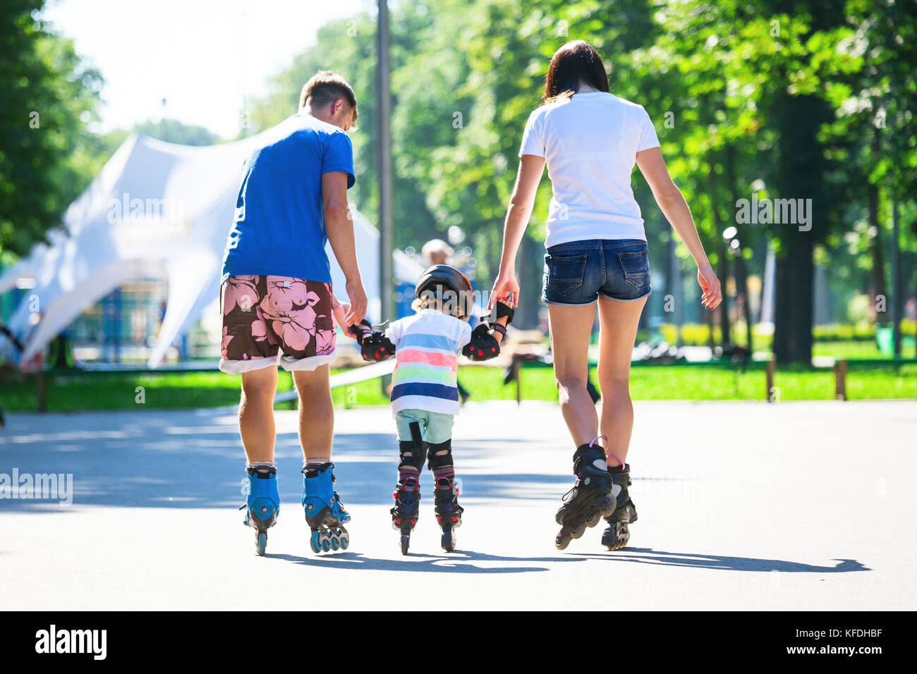 Portait of cute baby boy and his mom learning inline skating with ...