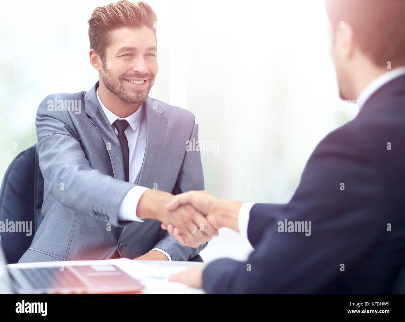 Business colleagues sitting at a table during a meeting with two male ...